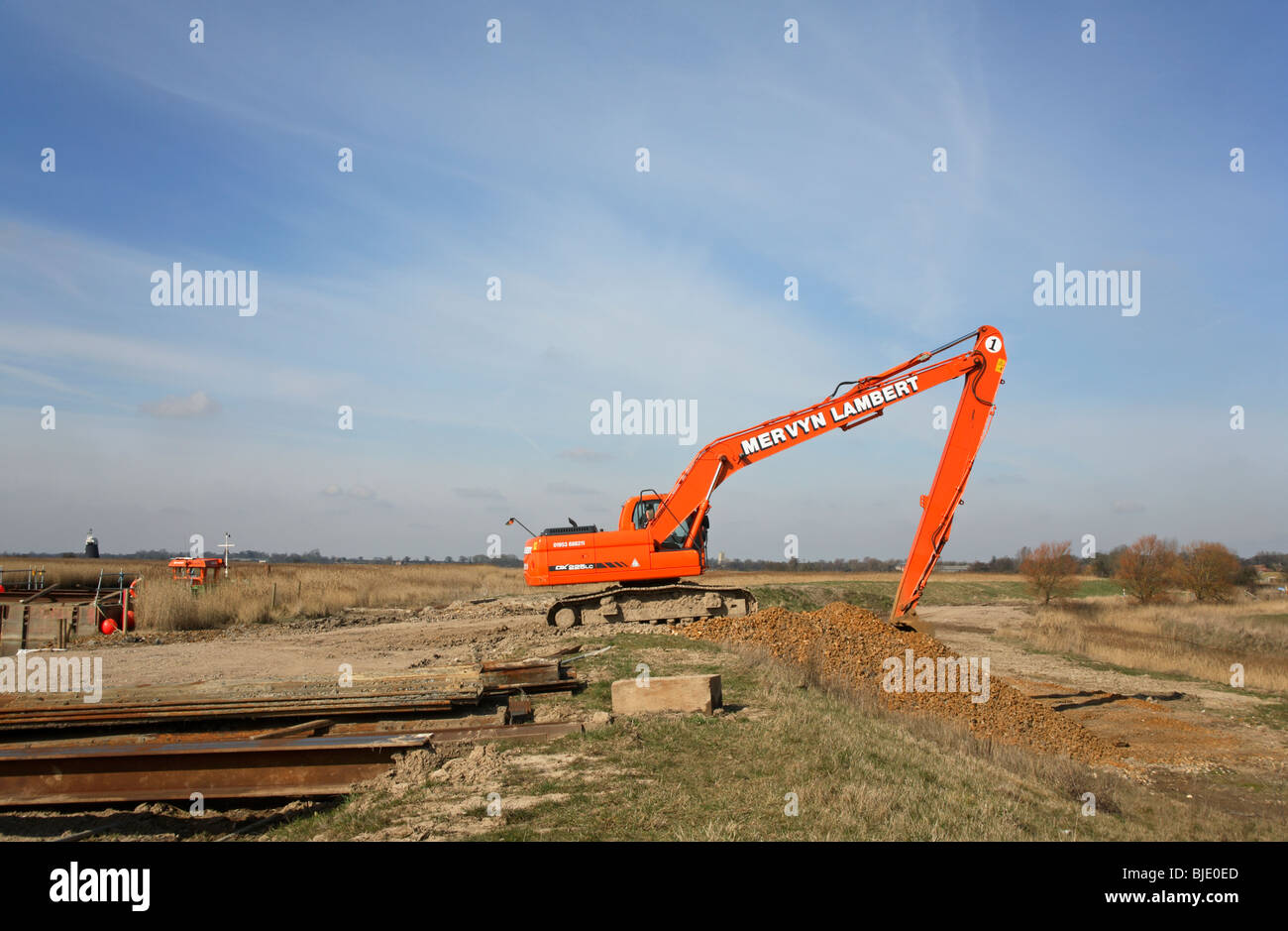 A mechanical digger performing river bank maintenance work near Mautby ...