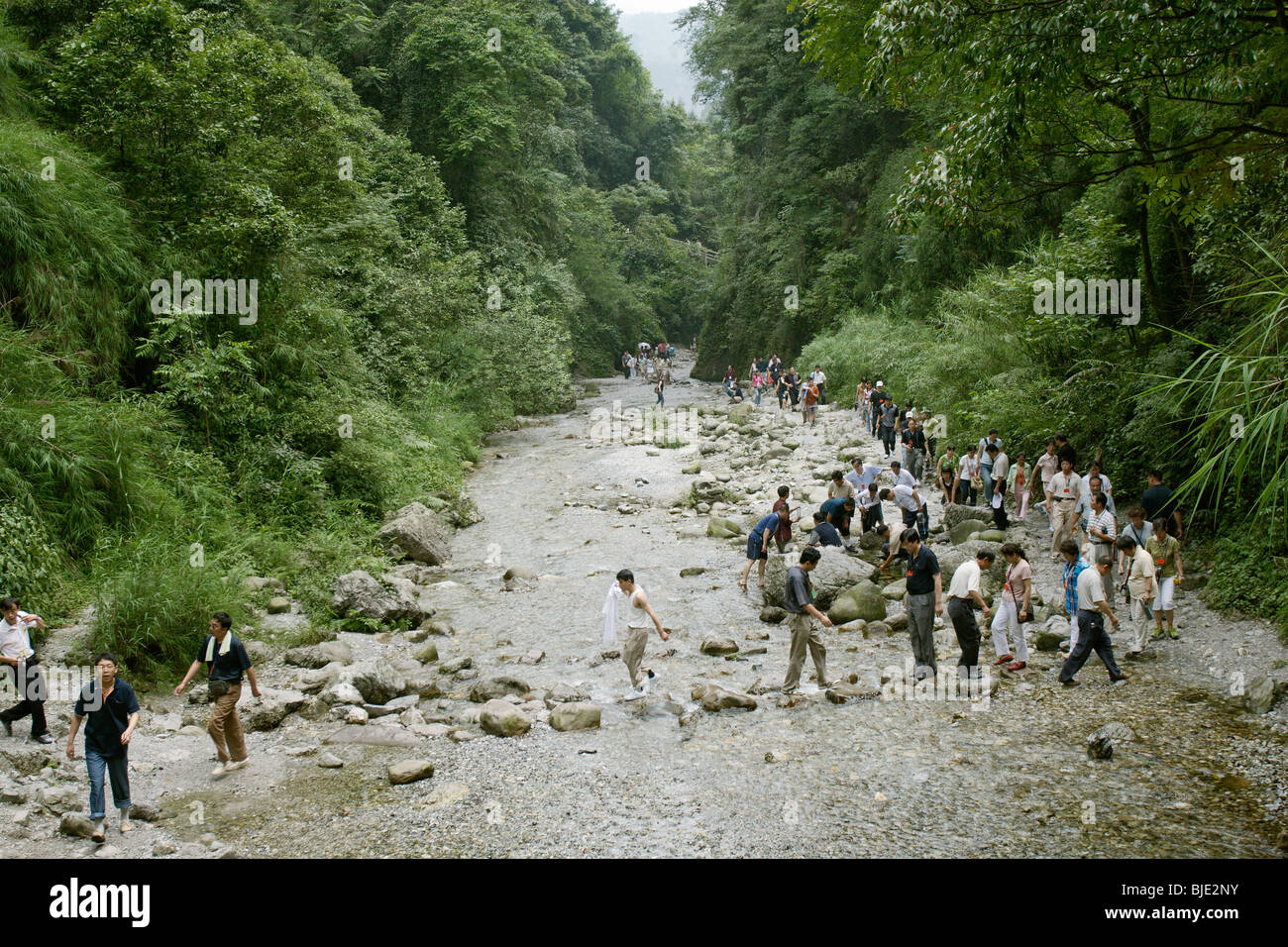 Crowd of Chinese tourists and pilgrims walking along a path on Emei ...