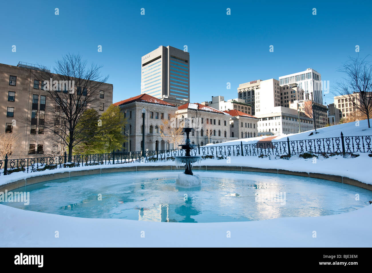 A frozen and snow covered fountain in the park of the Capitol buildings ...