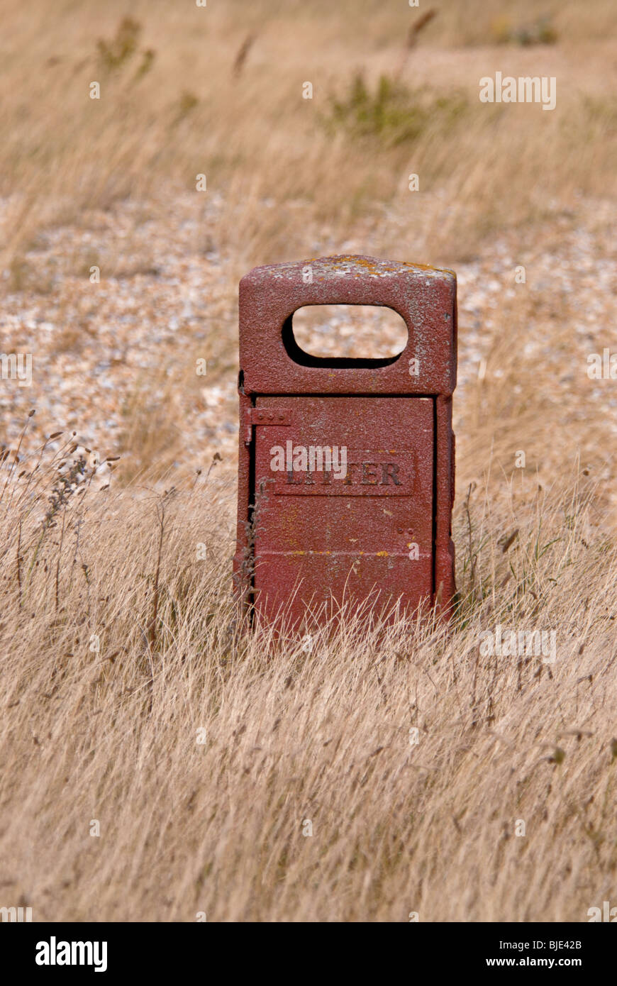 Litter bin on pebble beach with grass Stock Photo - Alamy