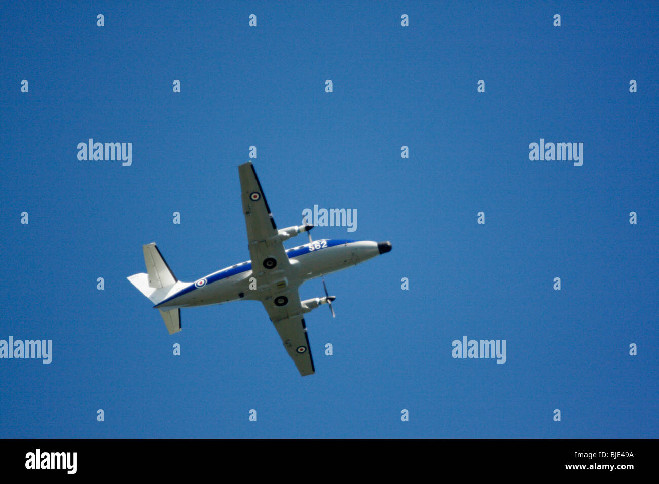 Small Aeroplane in Flight Seen From Below aginst a Blue Sky Stock Photo ...