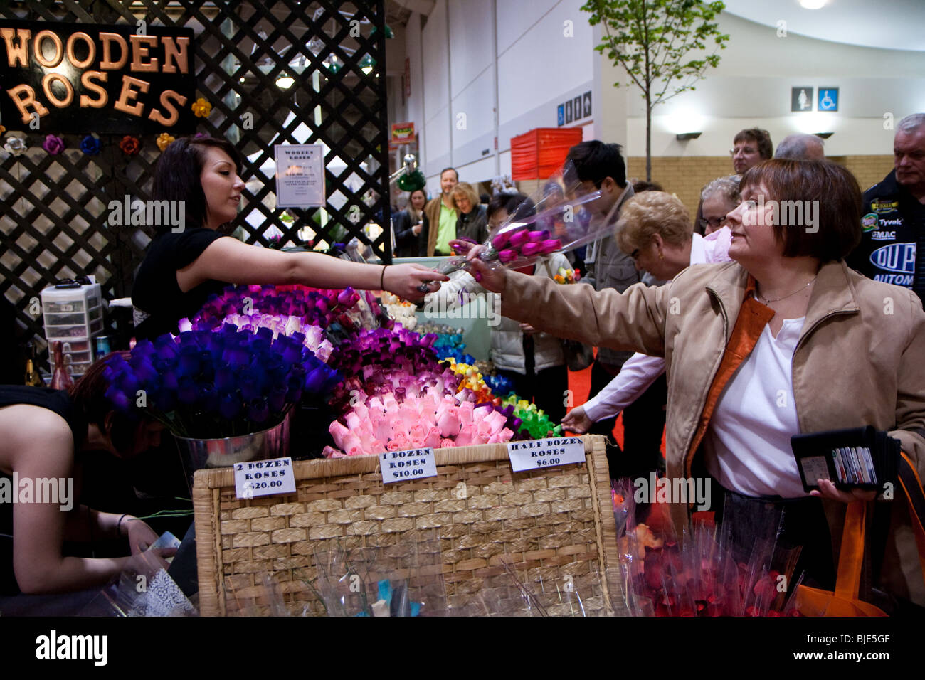 A customer buying a bunch of wooden flower roses Stock Photo - Alamy