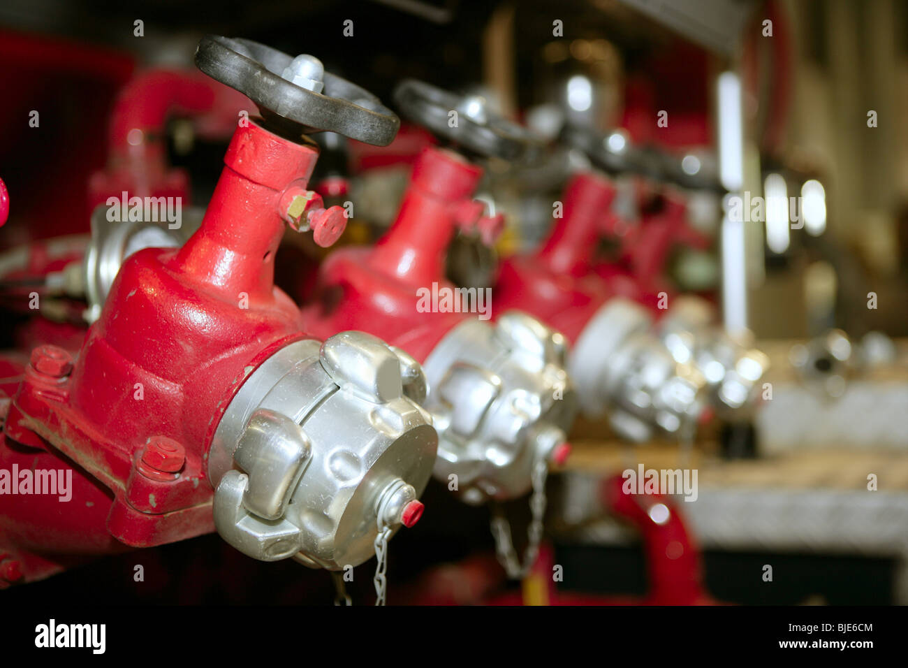 Fireman fire truck hose faucets in a row red and silver Stock Photo - Alamy