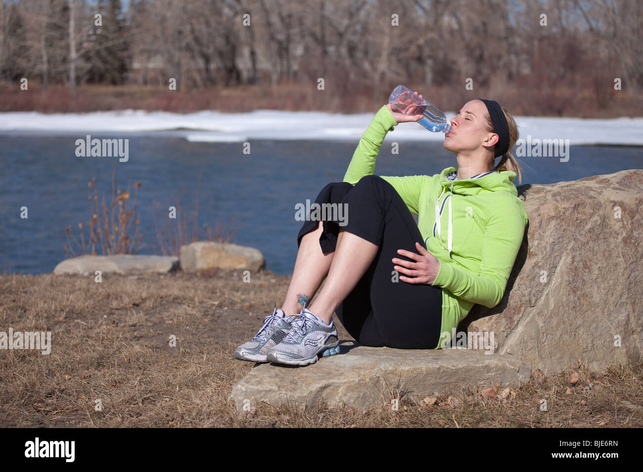 Fit woman drinking water outdoors in nature Stock Photo - Alamy