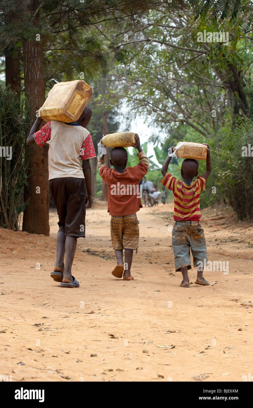 Children collecting water from well and carrying home Stock Photo - Alamy