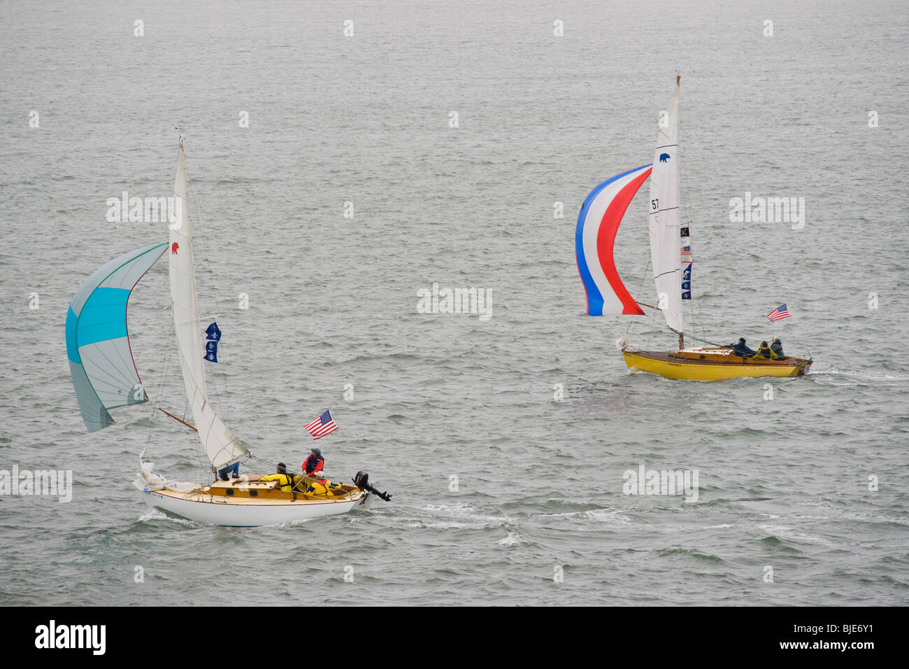 Two sailboats, both flying spinnakers, racing downwind on San Francisco ...