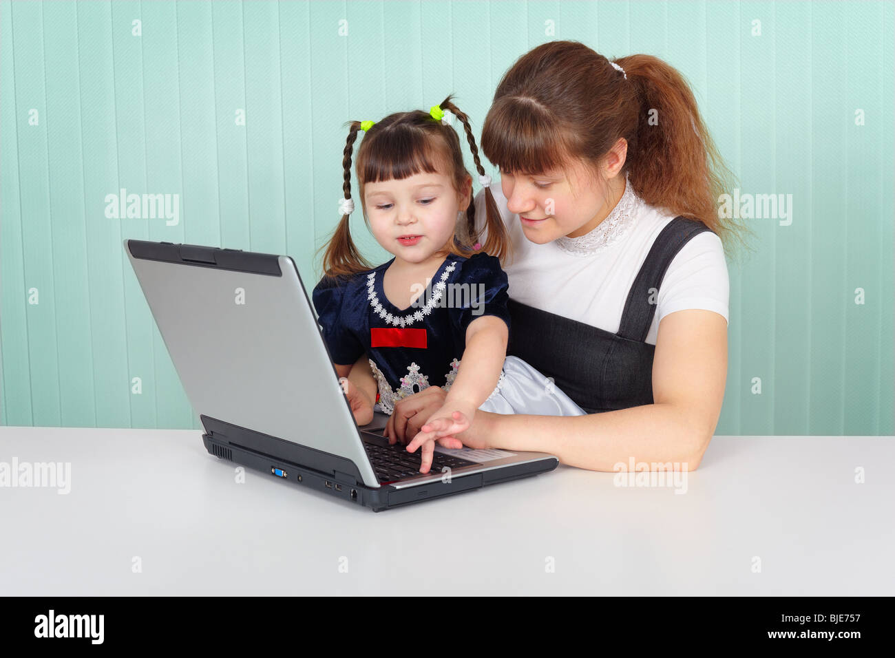 Mom shows daughter work on computer at table Stock Photo - Alamy