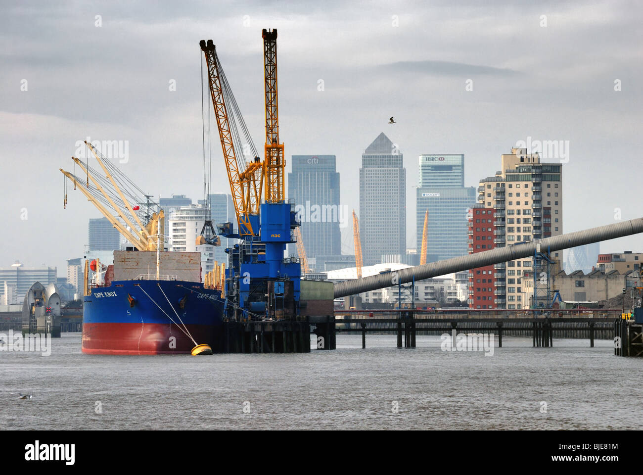 Ship unloading cargo with Canary Wharf in background Stock Photo - Alamy
