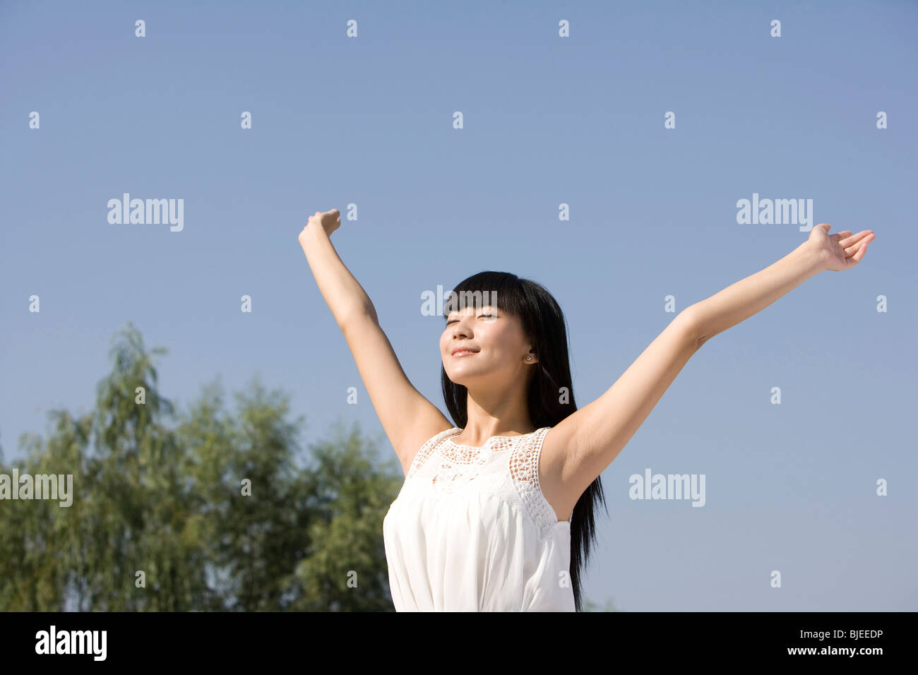 Young woman standing outdoors,arms out-stretched Stock Photo - Alamy