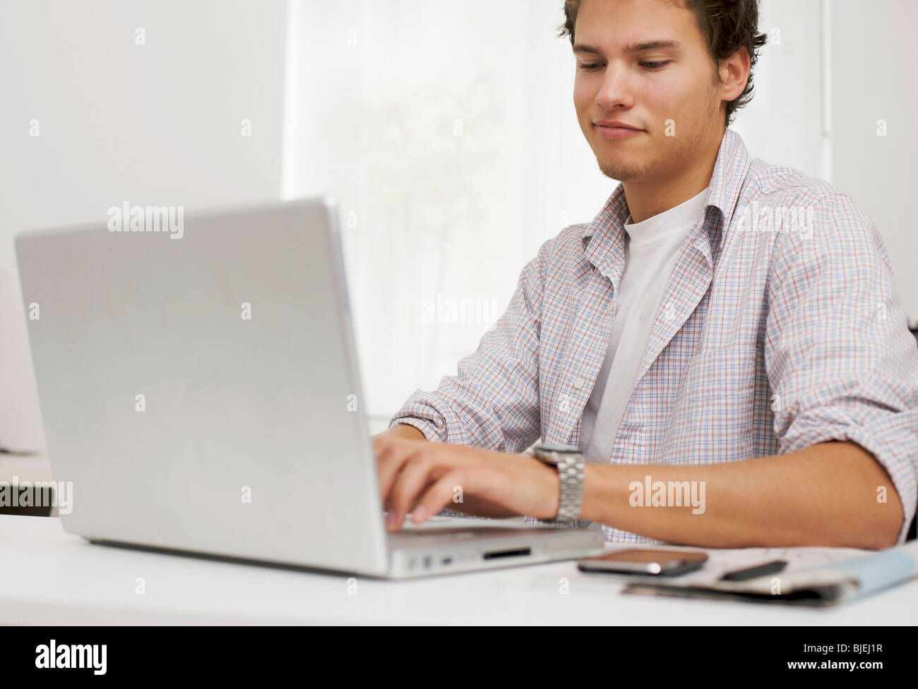 Young man using notebook, waist up Stock Photo - Alamy