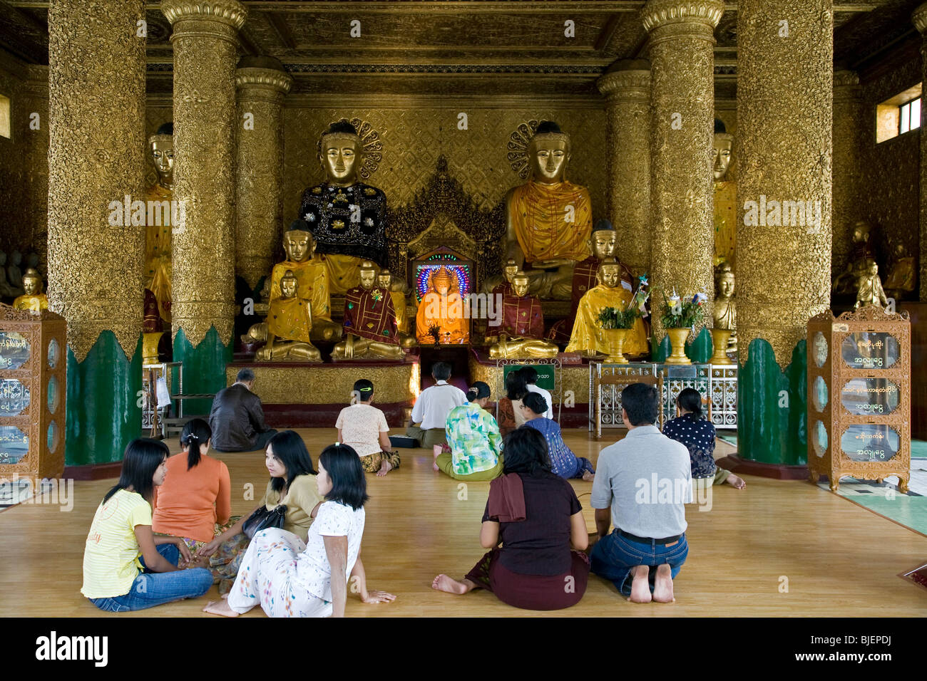Burmese people praying in front of Buddha statues. Shwedagon Paya ...
