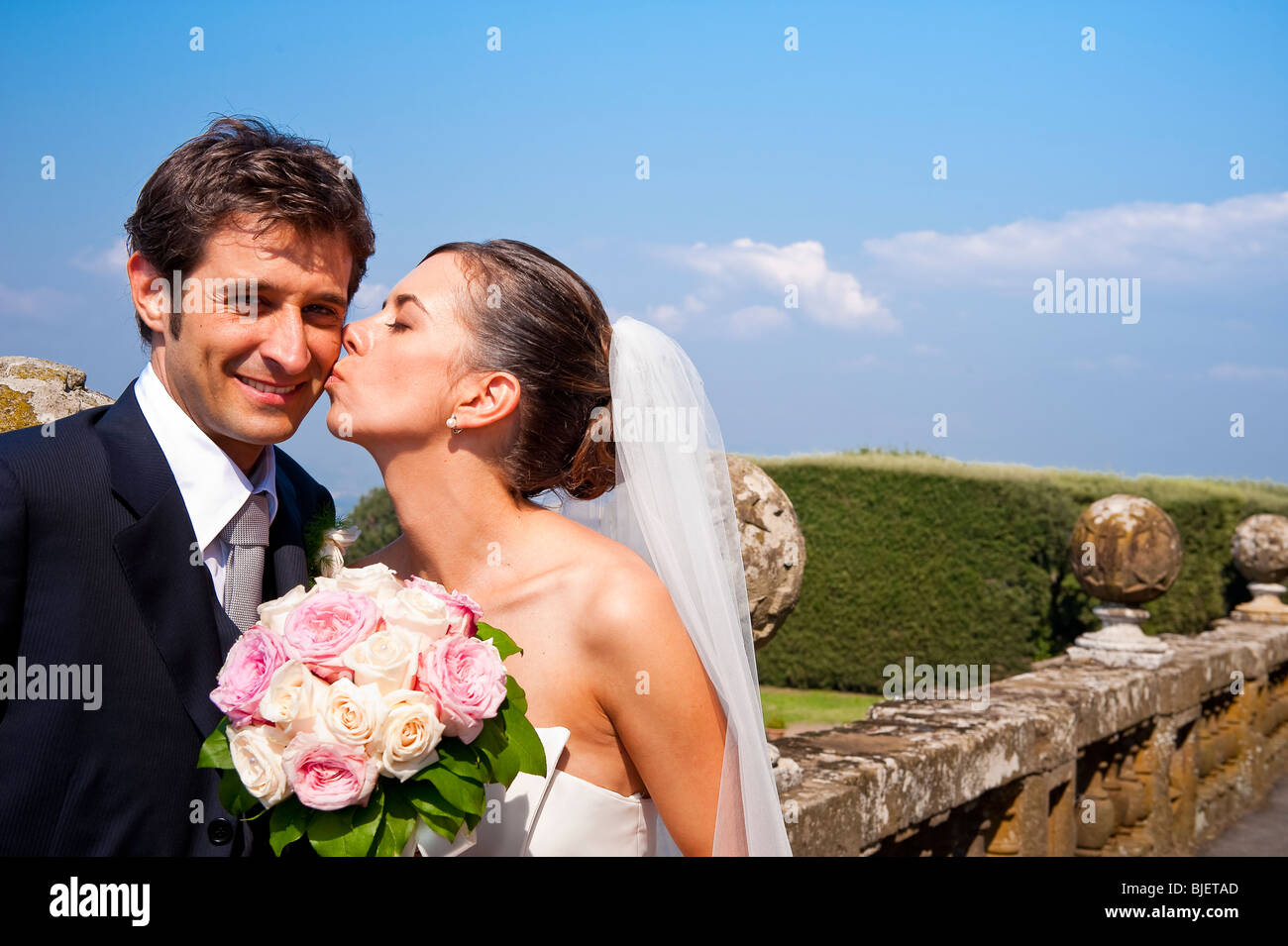 Bride kissing groom in a terrace Stock Photo - Alamy