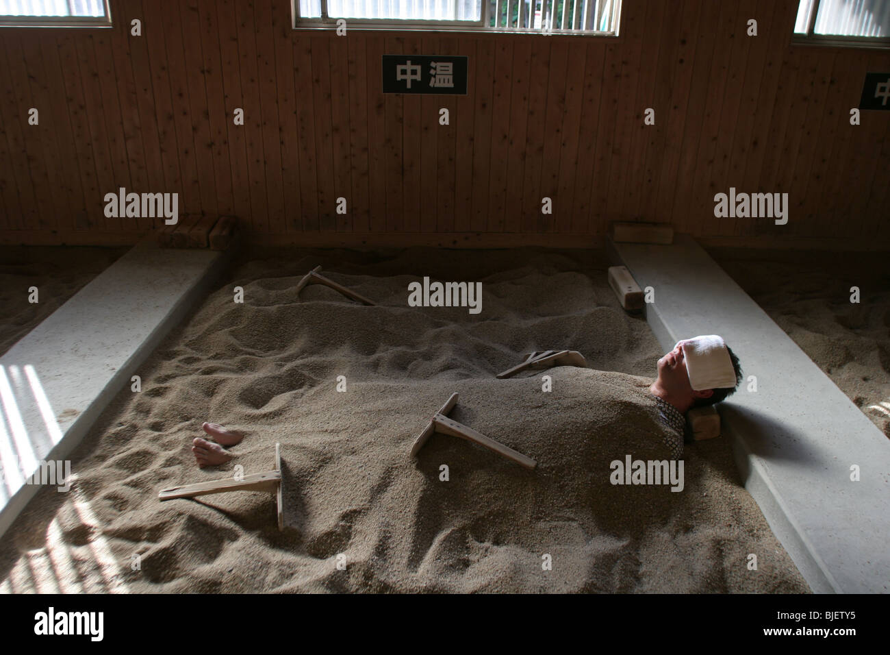 Man takes a sand bath at the 'Hyoten Onsen', Beppu, Japan. 20.10.2005 ...