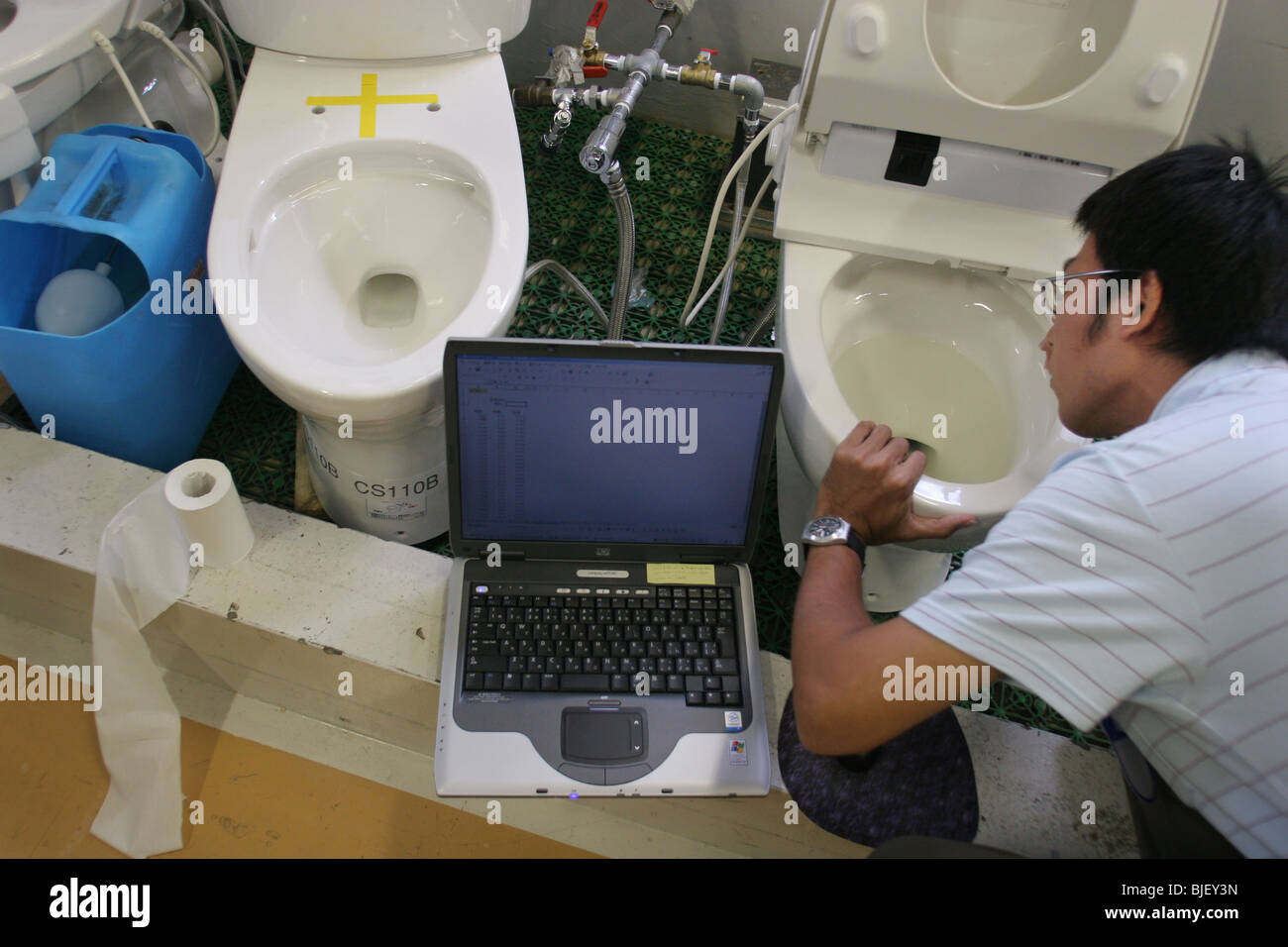 An employee checks the water functions of various types of toilets, in ...