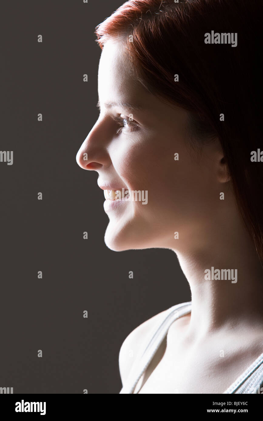 Young woman smiling, side view portrait Stock Photo - Alamy