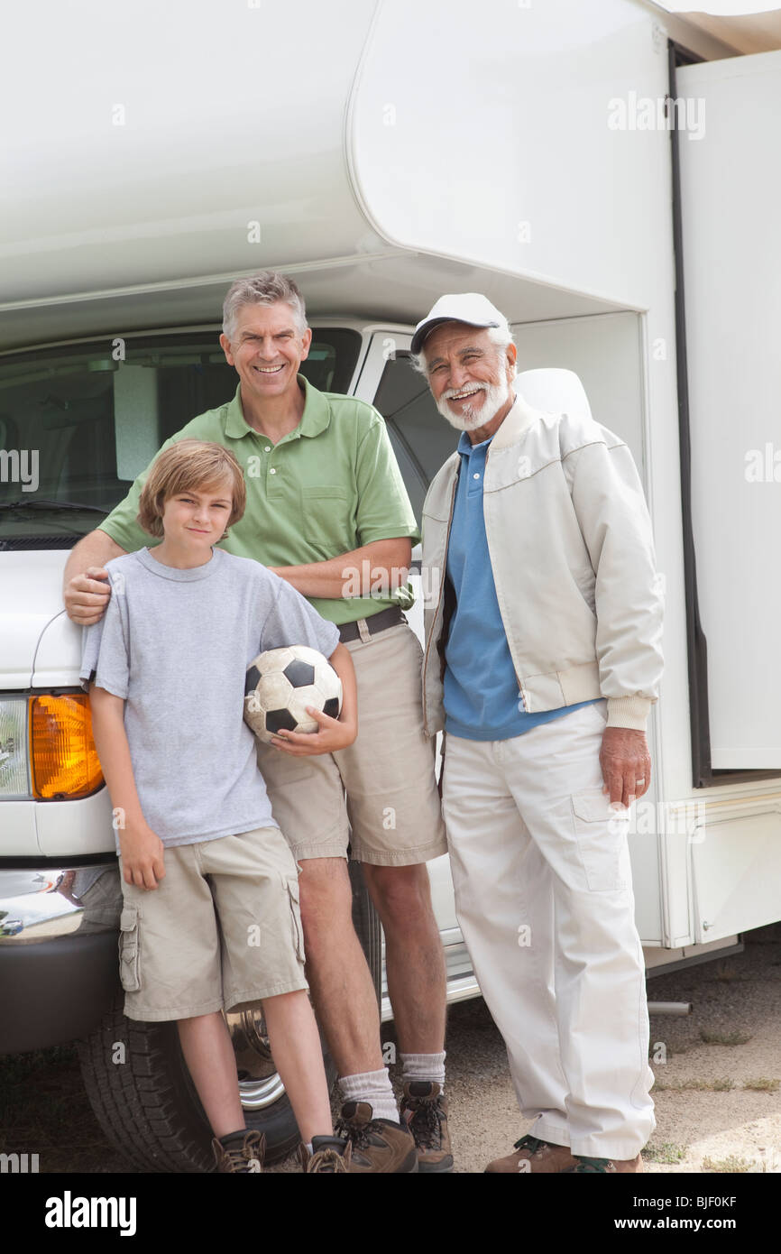 Father, son and grandson stand with RV home Stock Photo - Alamy