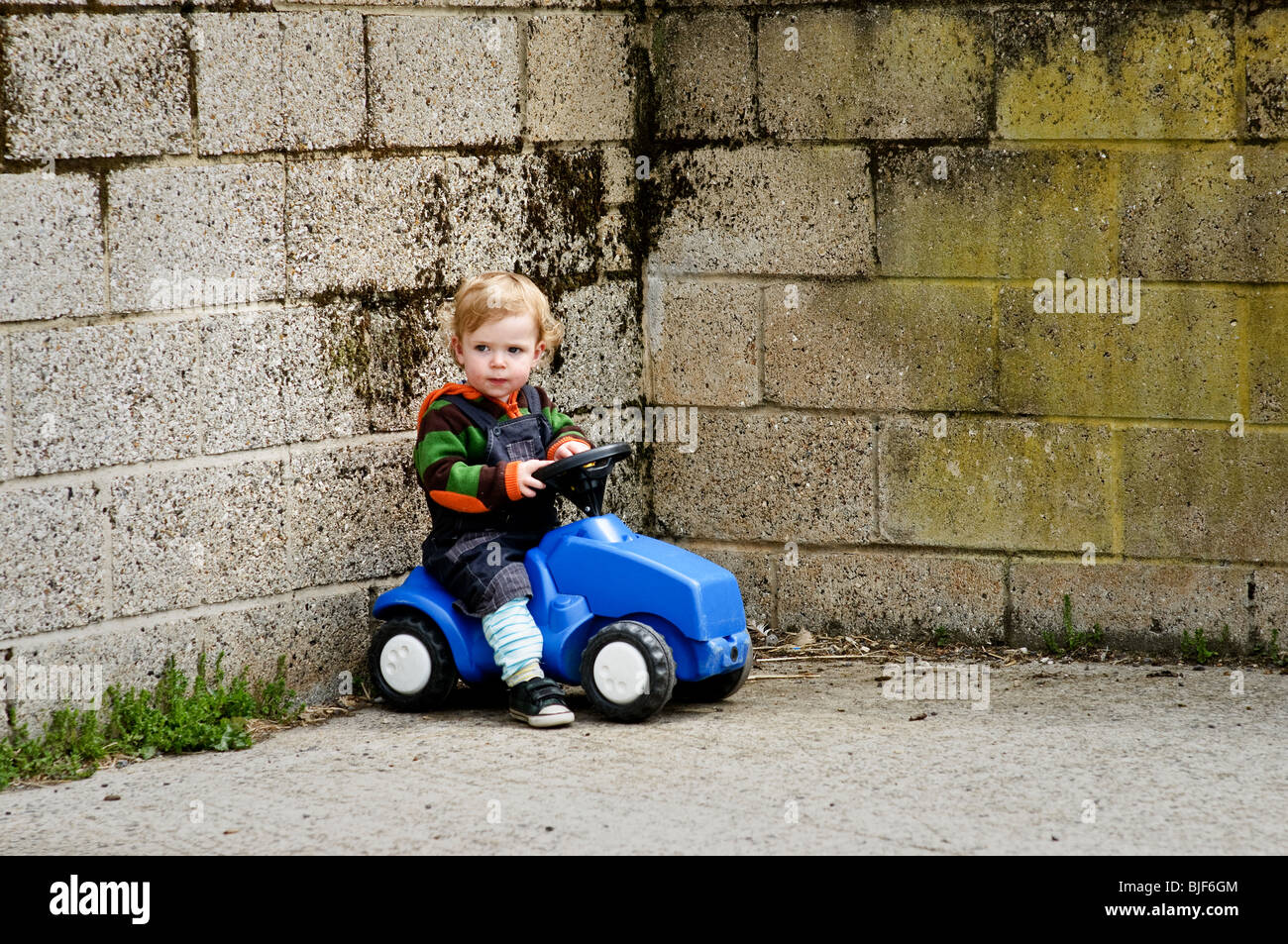 Little boy playing on a push along car Stock Photo - Alamy