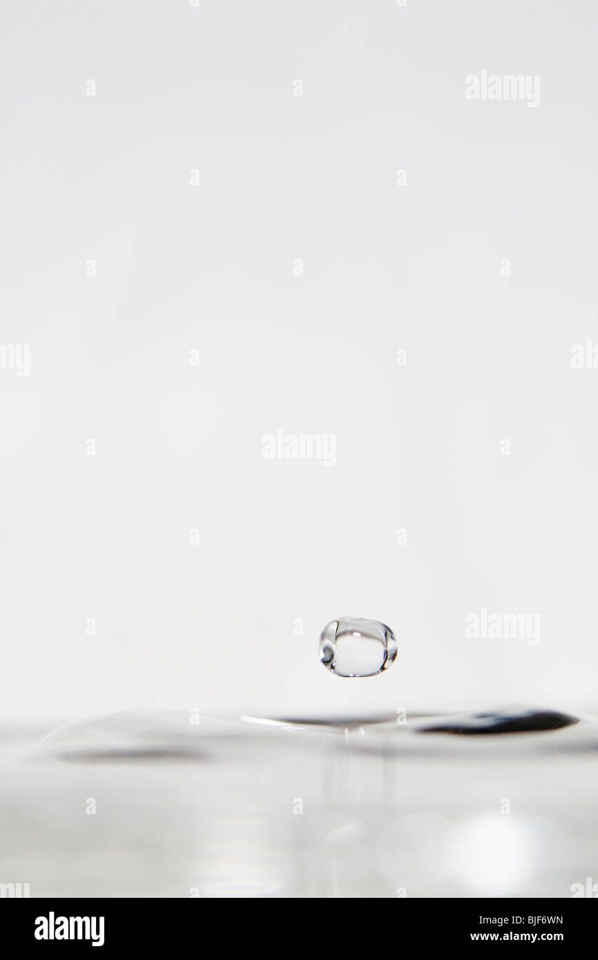 High speed photograph of a water droplet bouncing off a flat water ...