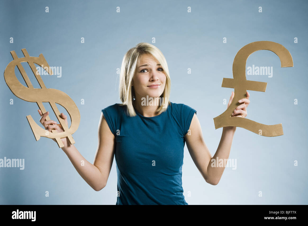 woman holding up currency symbols Stock Photo - Alamy