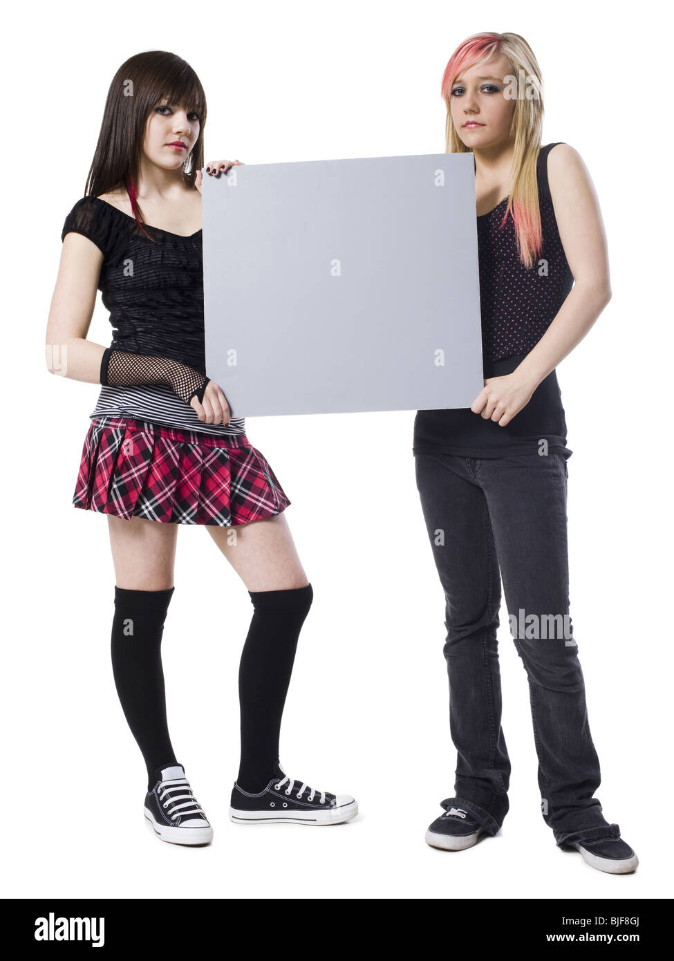 two rocker girls holding a sign Stock Photo - Alamy