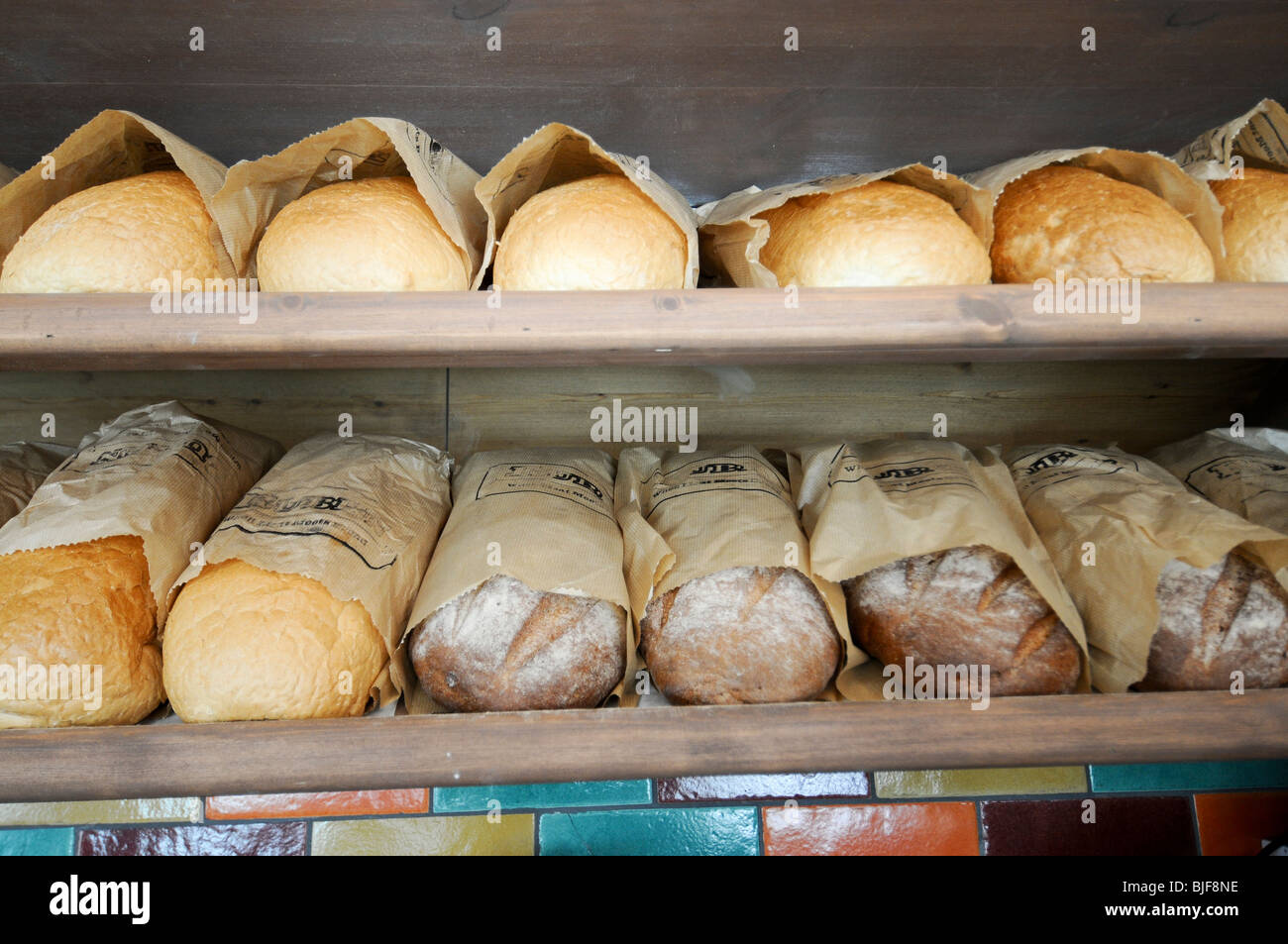 Loaves of bread displayed on a shelf in a bakery shop Stock Photo - Alamy
