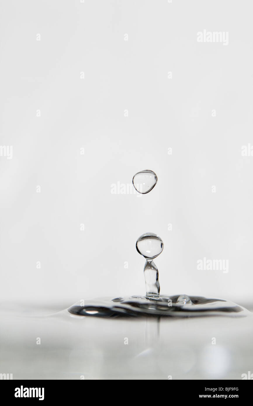 High speed photograph of a water droplet bouncing off a flat water ...