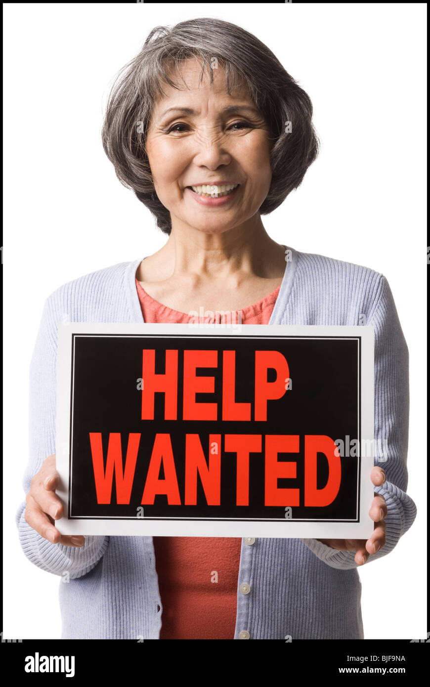 senior woman holding help wanted sign Stock Photo - Alamy