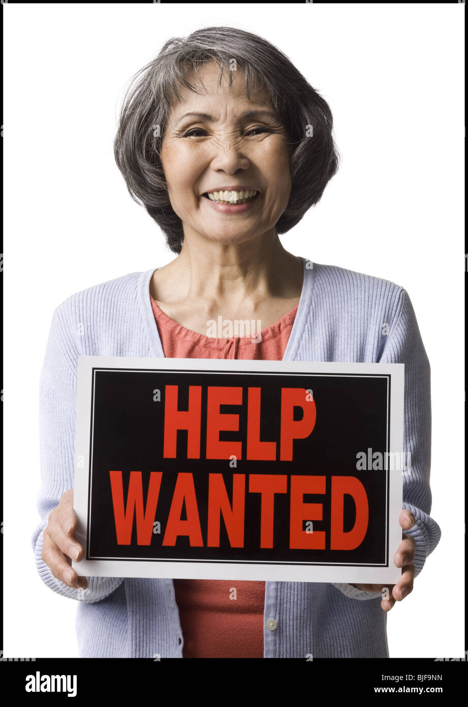 senior woman holding help wanted sign Stock Photo - Alamy