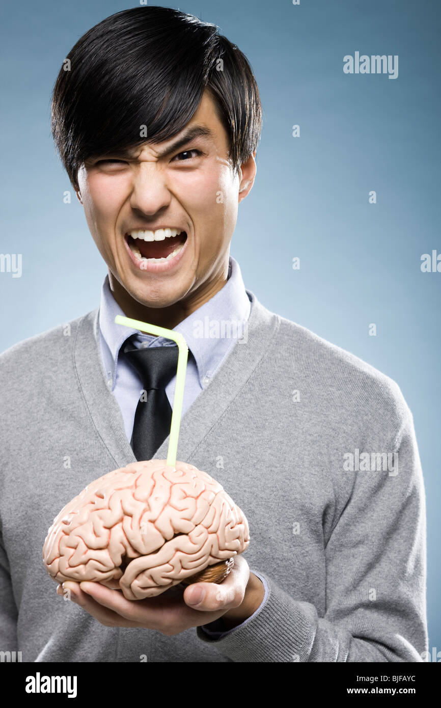 man holding a brain with a drinking straw sticking out of it Stock ...