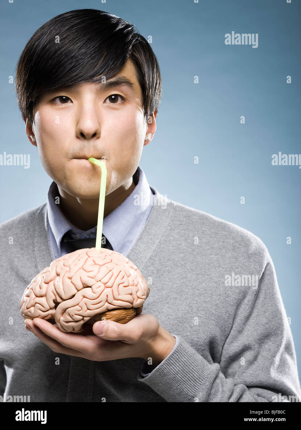 man holding a brain with a drinking straw sticking out of it Stock ...