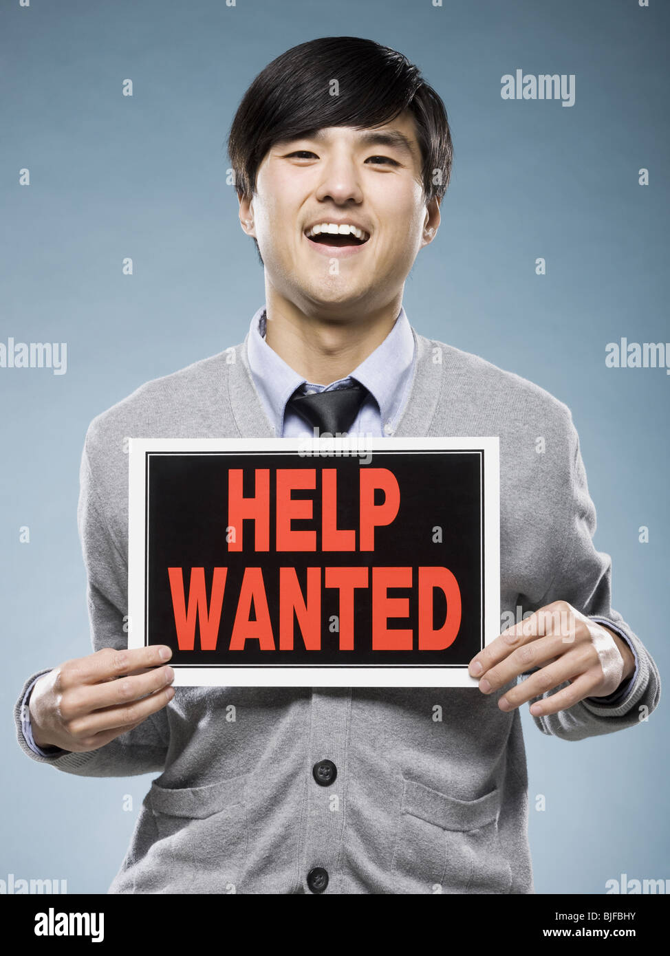 man holding help wanted sign Stock Photo - Alamy