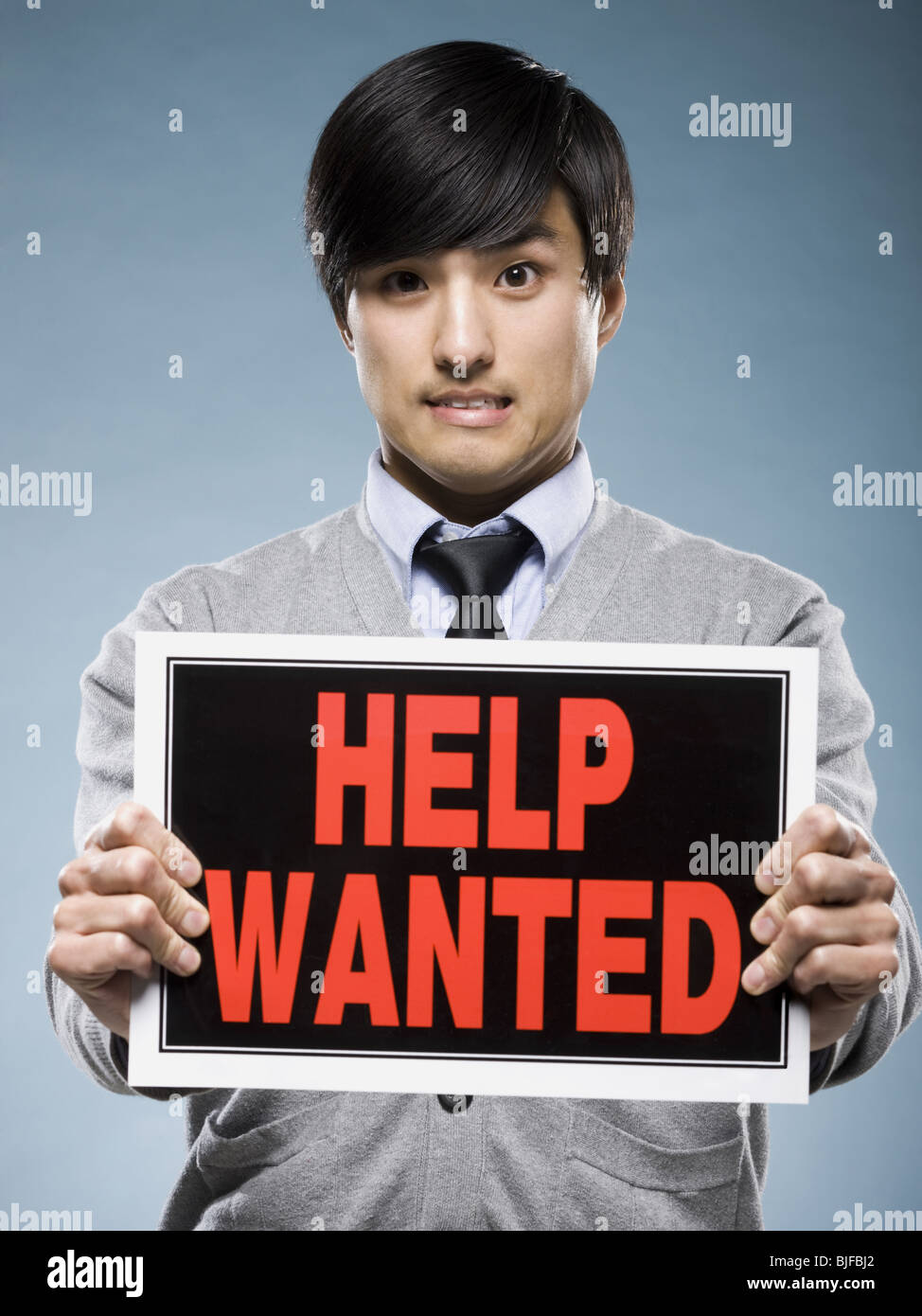 man holding help wanted sign Stock Photo - Alamy