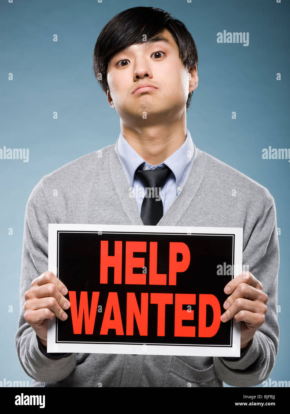 man holding help wanted sign Stock Photo - Alamy