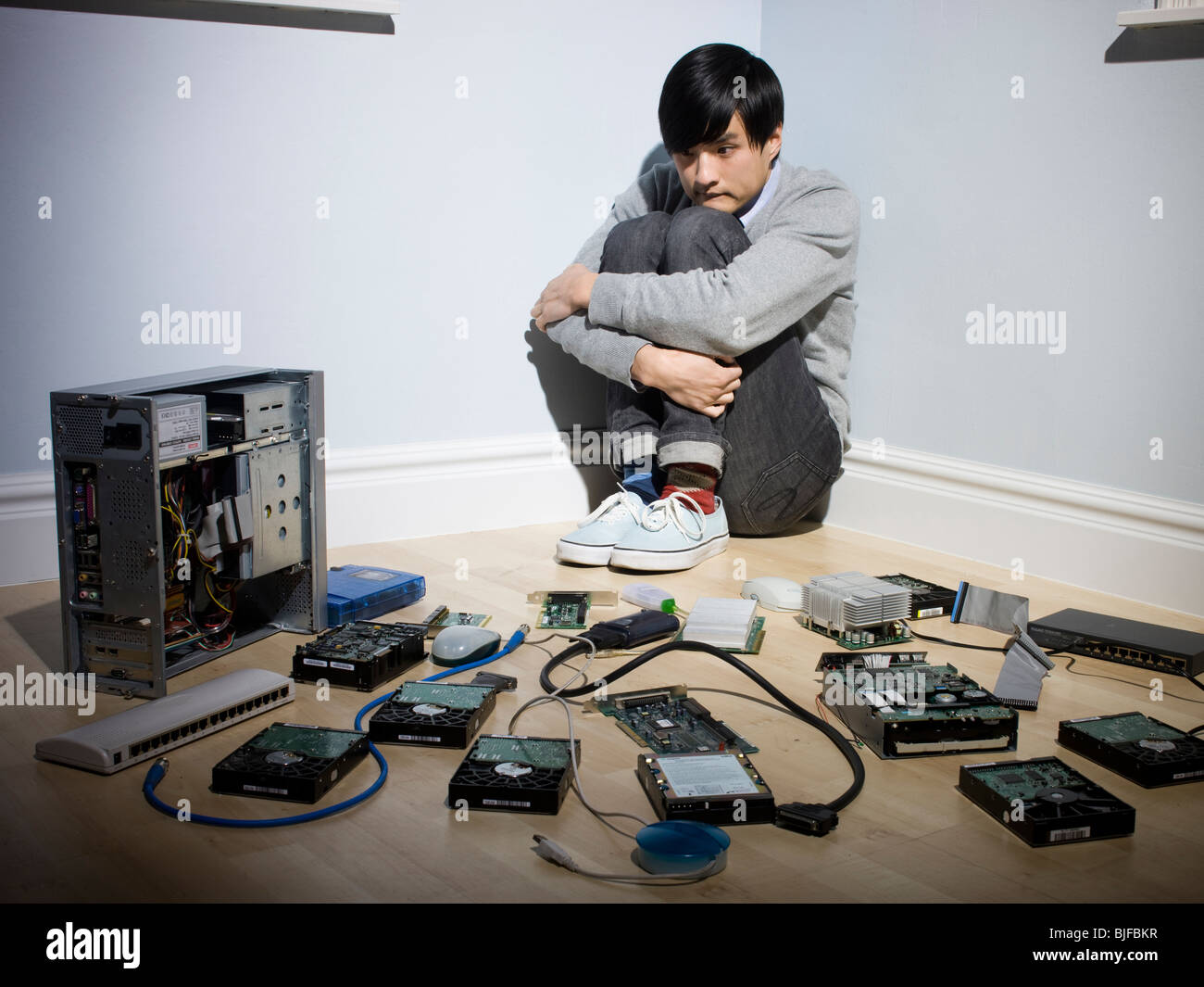 man in the corner surrounded by computer parts Stock Photo - Alamy