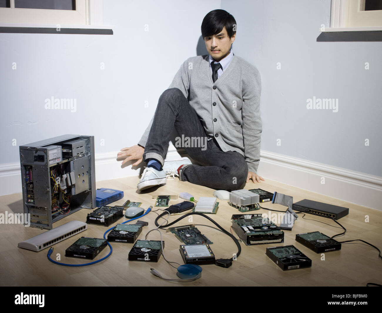 man in the corner surrounded by computer parts Stock Photo - Alamy