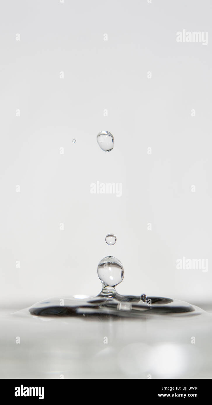 High speed photograph of a water droplet bouncing off a flat water ...