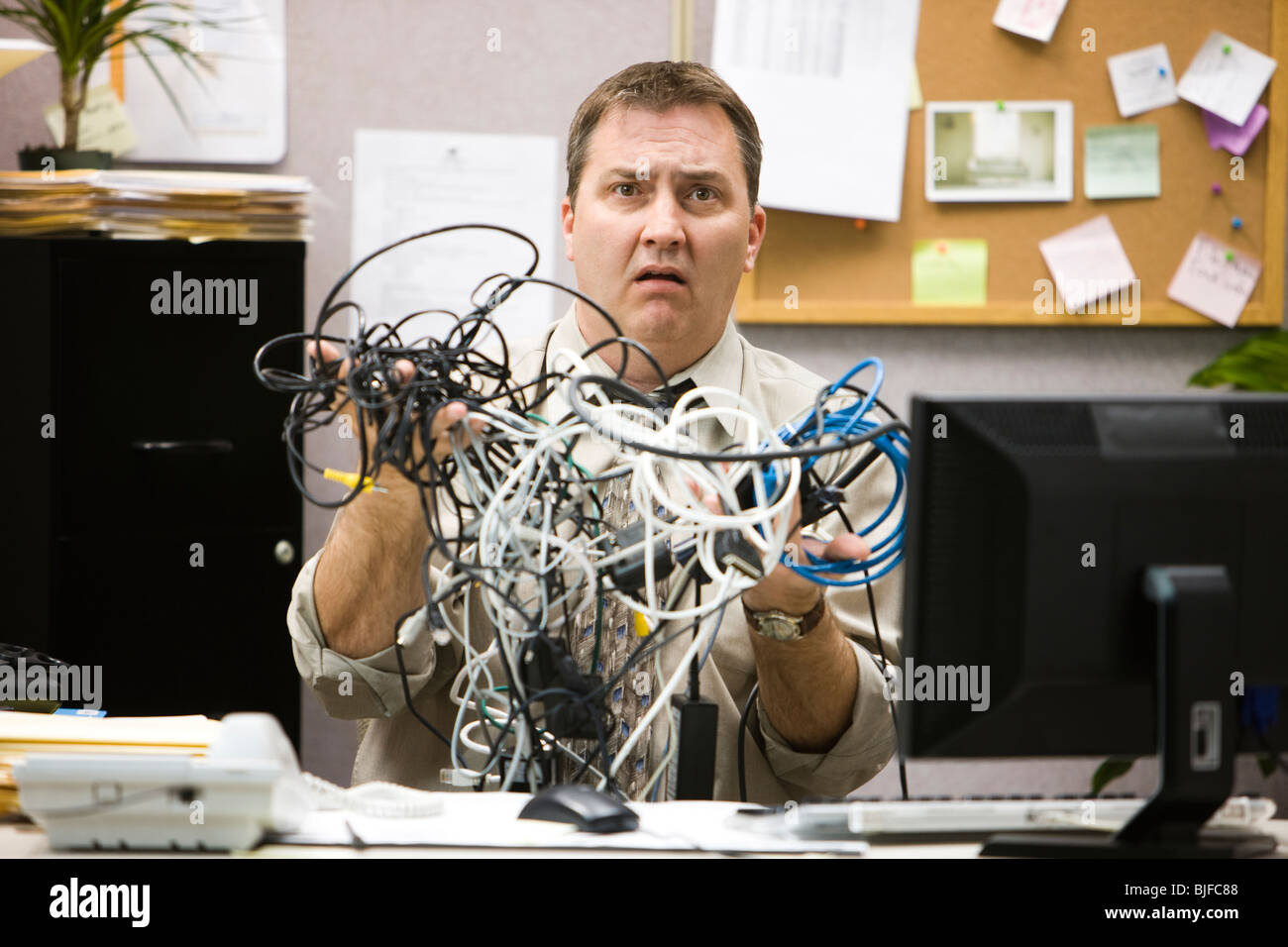 man trying to figure out computer wiring Stock Photo - Alamy