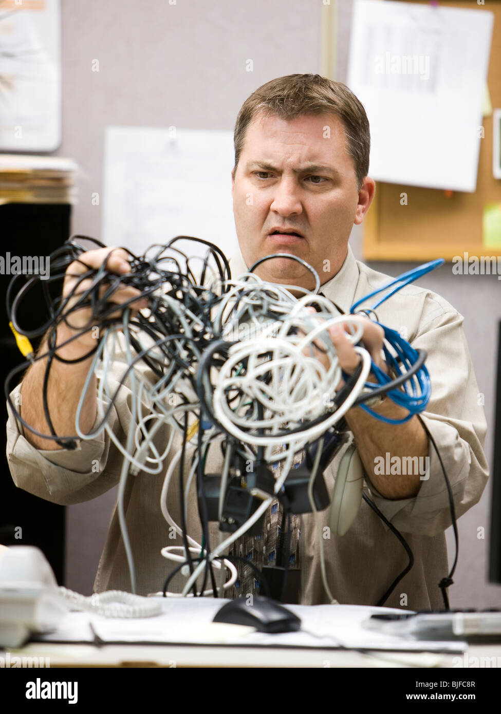man trying to figure out computer wiring Stock Photo - Alamy