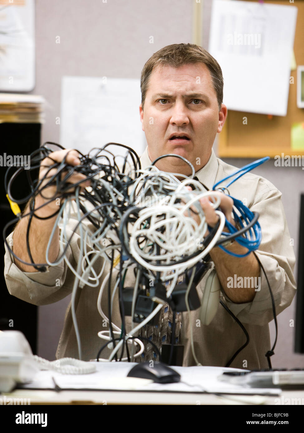 man trying to figure out computer wiring Stock Photo - Alamy