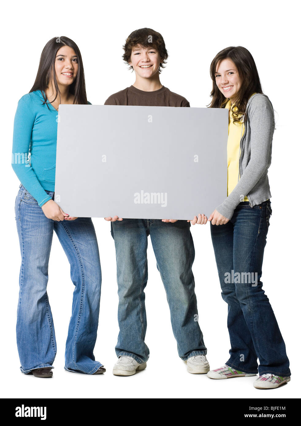 three teenagers holding a sign Stock Photo - Alamy