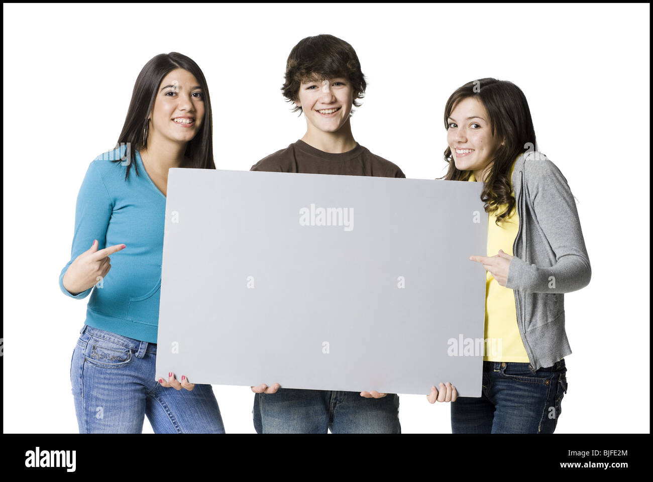 three teenagers holding a sign Stock Photo - Alamy