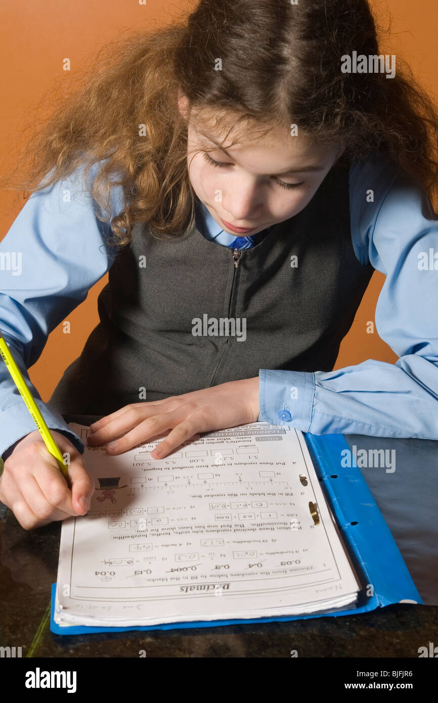 young girl dressed in school uniform doing homework Stock Photo - Alamy