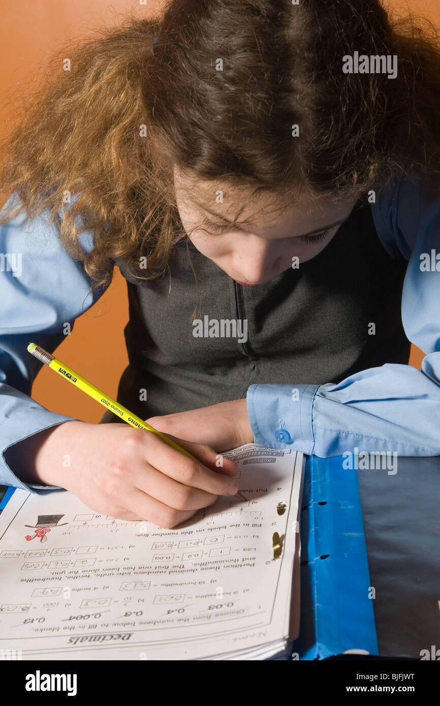 young girl dressed in school uniform doing homework Stock Photo - Alamy