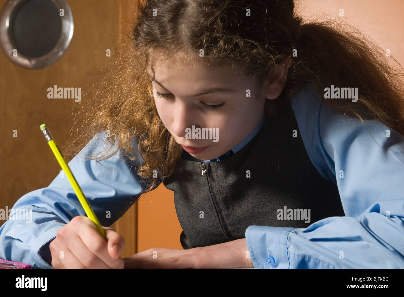 young girl dressed in school uniform doing homework Stock Photo - Alamy