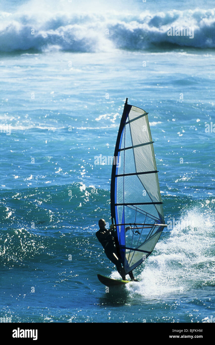 Windsurfer in action on the ocean against crashing waves Stock Photo ...
