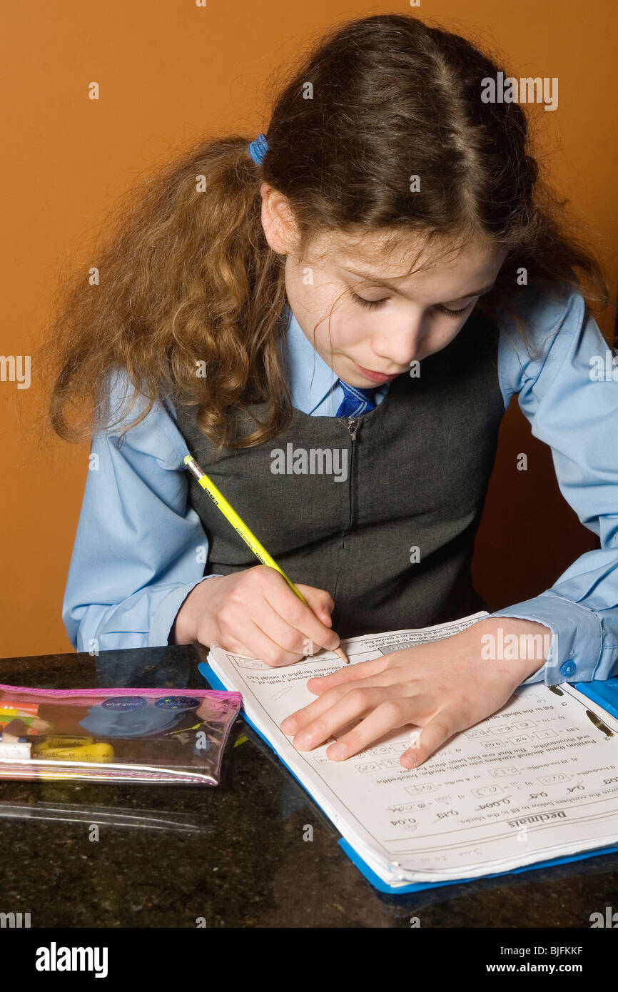 young girl dressed in school uniform doing homework Stock Photo - Alamy