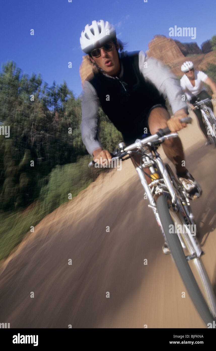 Two cyclists ride down an off-road mountain track Stock Photo - Alamy