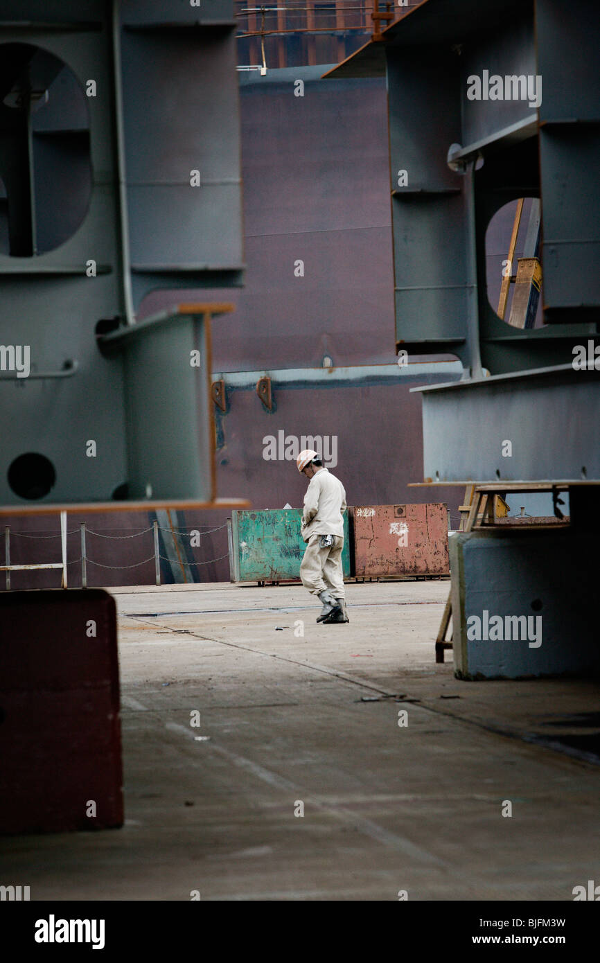 Tired worker at a huge shipyard in China Stock Photo - Alamy