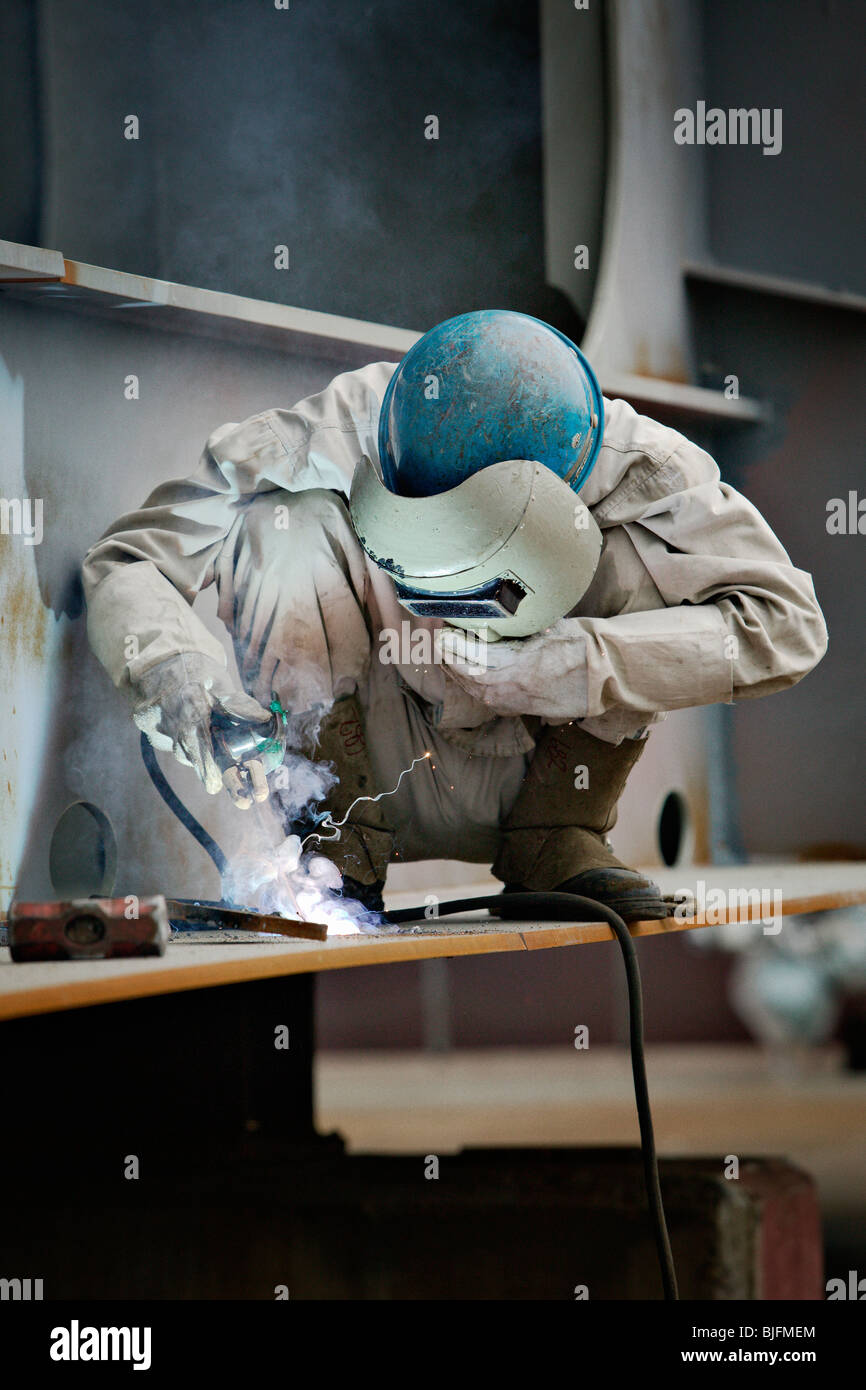Man welding at a huge shipyard in China Stock Photo - Alamy