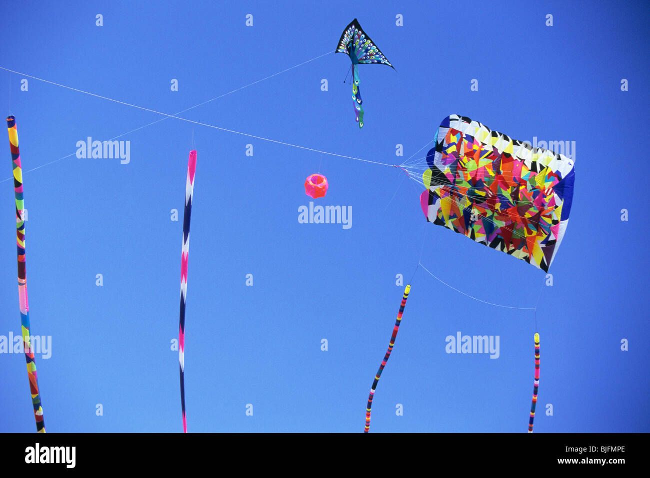 Colourful kites flying high in sky Stock Photo - Alamy